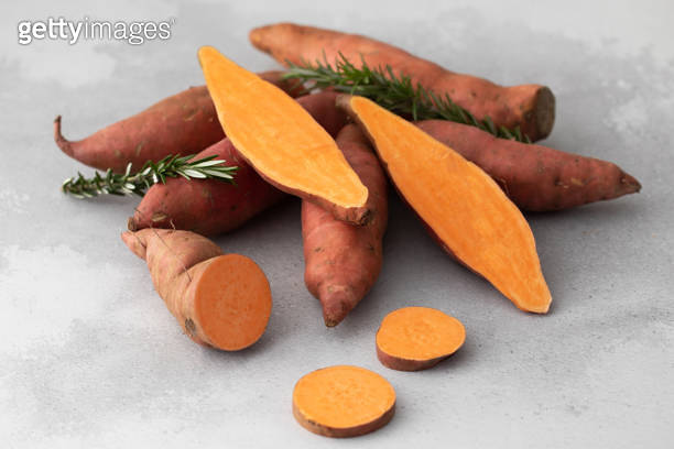 Raw sweet potatoes whole and cut. Orange kumara, sweet potato ...