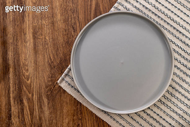 Empty plate and napkin on dark wooden table. Empty tray. Mockup for ...