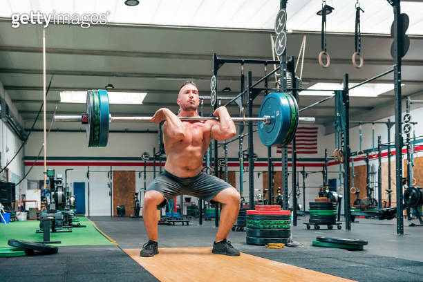 Strong man doing power clean exercise with barbell in gym (1648191702 ...