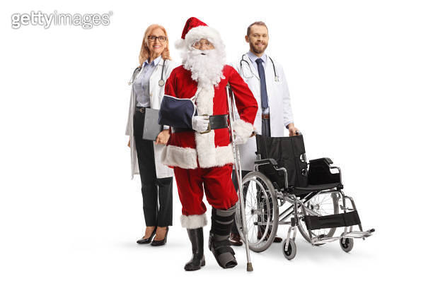 Injured santa claus with a foot brace and arm sling standing with a ...