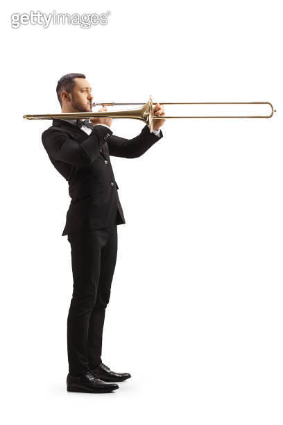 Full length profile shot of an elegant male musician playing a trombone ...
