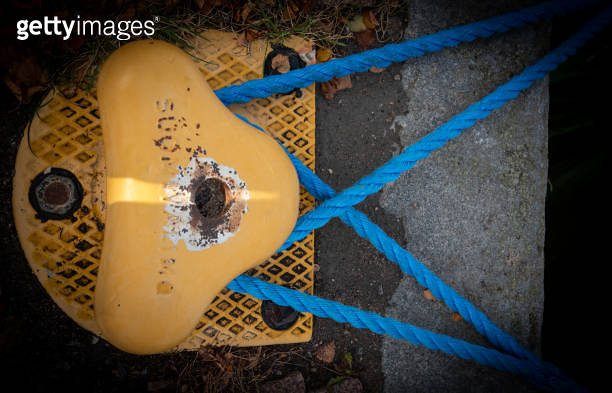 Details of a yellow mooring pole with safety rope for boat support and ...