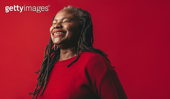 Elegant woman with dreadlocks laughing happily in a studio 이미지 ...