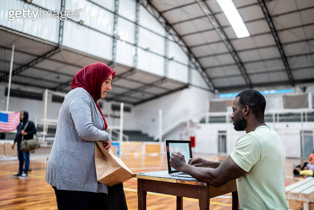 Soldier talking with a refugee woman while using the laptop at a ...