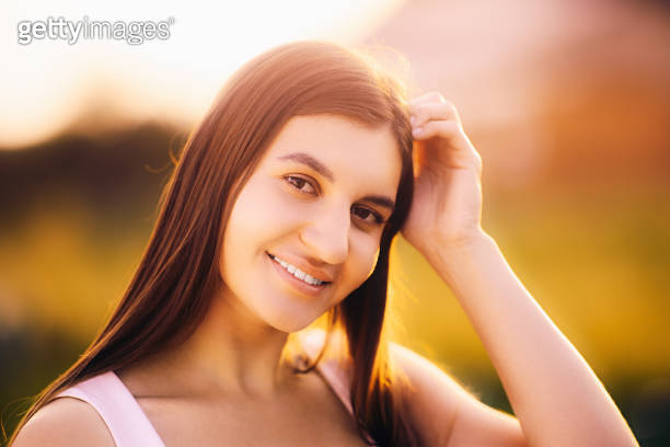 26 year old woman smiles while taking close-up portrait at sunset. 이미지 ...