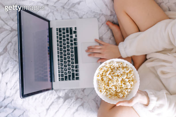 Popcorn viewed from above on bed. Woman eating popcorn. Human ha 이미지 ...