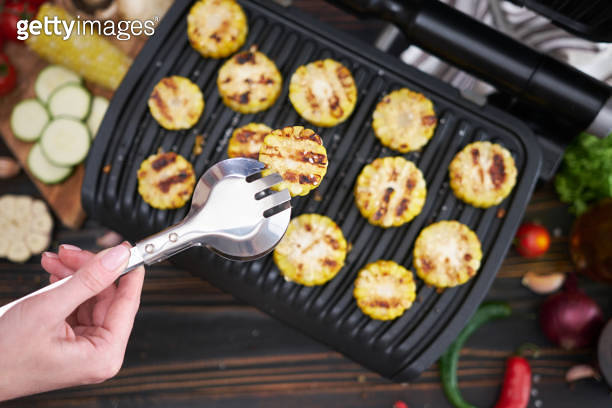 cooking at home on electric grill - sliced corn cobs (1495740111) - 게티이미지뱅크