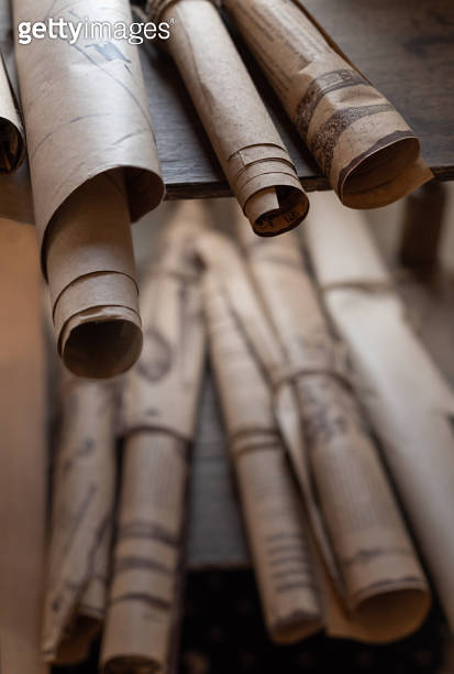 Old sheets of paper with text, maps and drawings folded into scrolls on ...