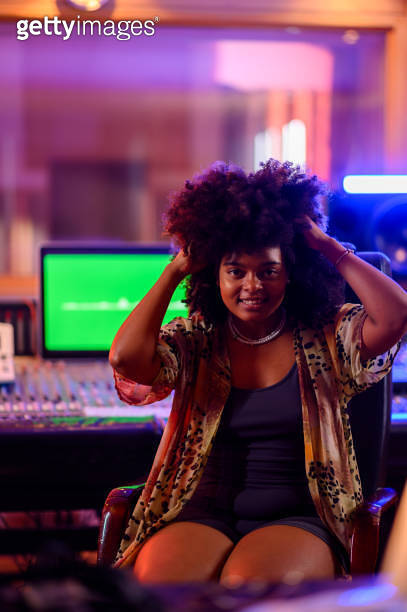 Portrait of music artist in music studio, posing in front of mixing ...
