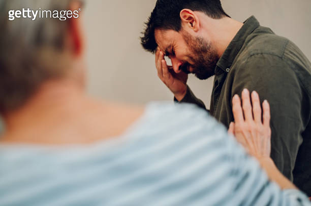 Sad young man talking about his mental health on a group therapy ...