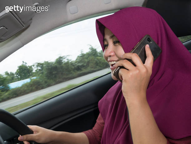 Female Driver Making a Call While Driving a Car (1479258000) - 게티이미지뱅크