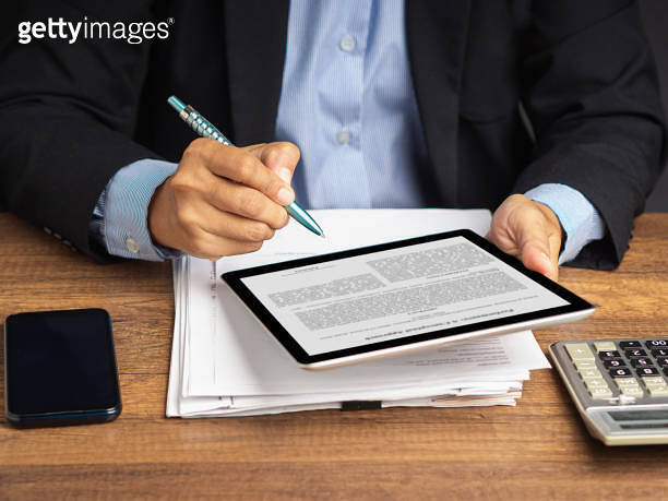 A businessman in a suit signing on lease contract or agreement on a ...