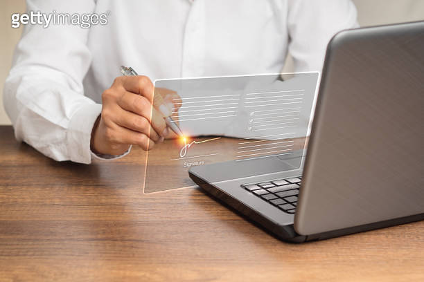 Businesswoman using a pen to sign an electronic digital document on a ...