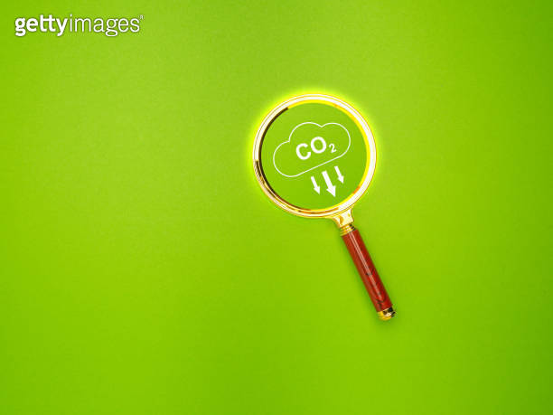Reduce CO2 emission icon inside the magnifier glass for focusing decrease CO2 or carbon dioxide ...