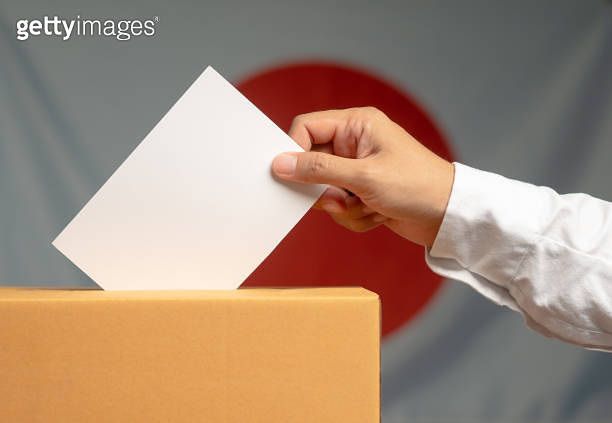 Election in Japan. Hand voter holding ballot paper putting into the ...