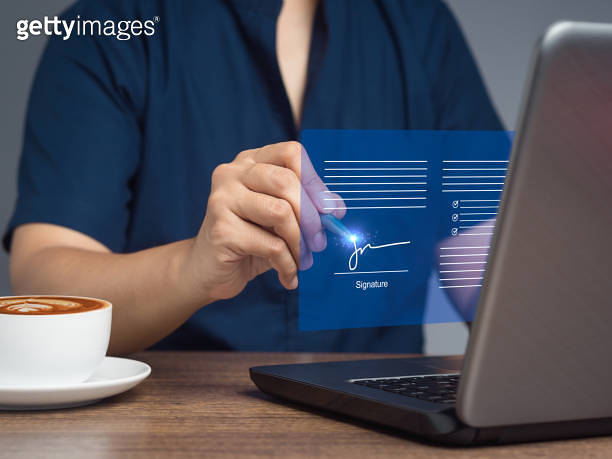 Signature Electronic. Businessman uses a pen to sign electronic ...