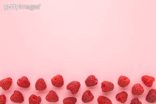 Fresh red raspberries on light pink table background. Pastel color ...