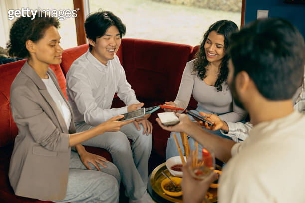 Happy group of friends sharing each other photos they made on phone on ...