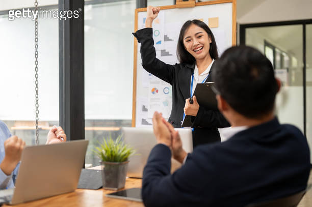 A confident Asian businesswoman lets anyone in the meeting ask a ...