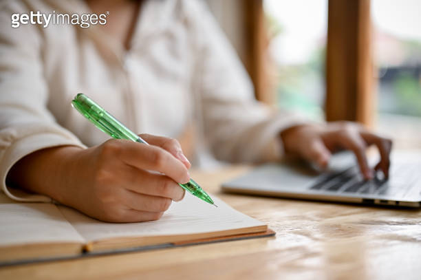 Close-up image of a young Asian female college student writing ...