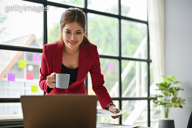 A beautiful businesswoman working on business reports at her desk. hard ...