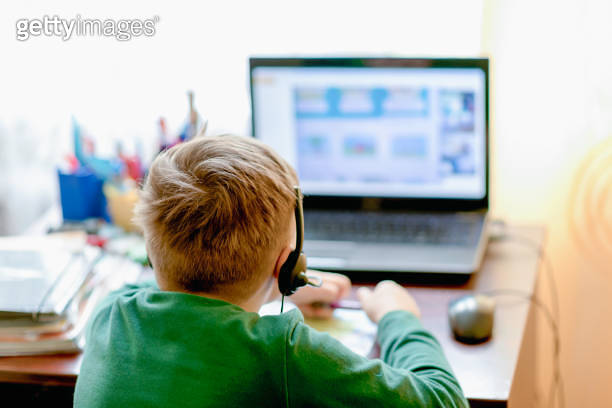 The schoolboy learns with laptop at a distance remote learning. Boy ...