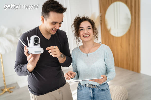 man and woman couple wife husband set up surveillance security camera ...