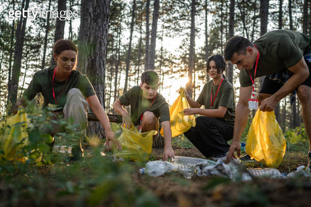 teenage friends young men women pick up waste garbage to clean forest ...