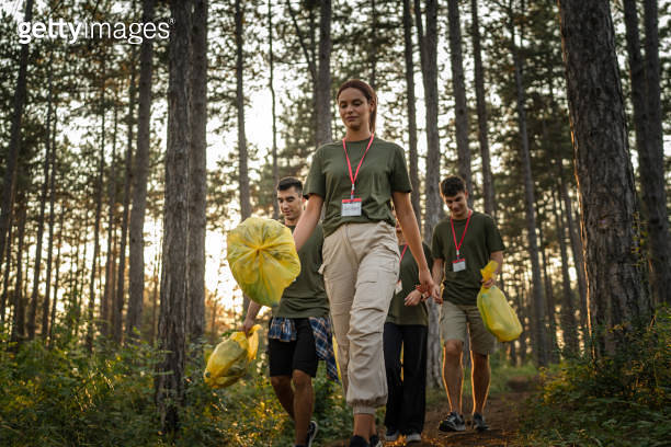 teenage friends young men women pick up waste garbage to clean forest ...