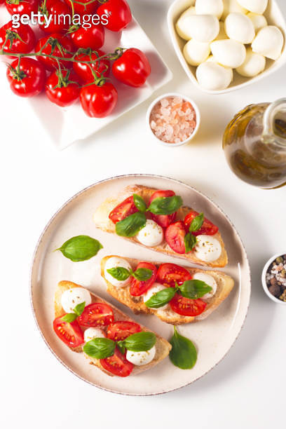 Tomato, basil and mozzarella cheese fresh made caprese bruschetta. Italian tapas, antipasti with ...