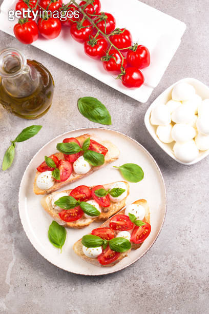 Tomato, basil and mozzarella cheese fresh made caprese bruschetta. Italian tapas, antipasti with ...