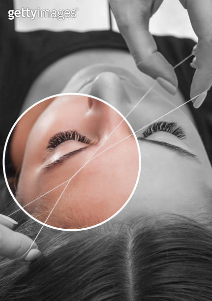 The make-up artist plucks eyebrows with a thread close-up. Women's ...