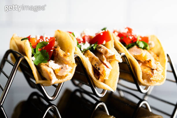 This photo showcases three delicious street tacos, sitting on a metal ...