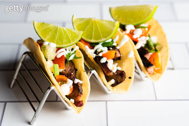 This photo showcases three mouth-watering street tacos, beautifully ...