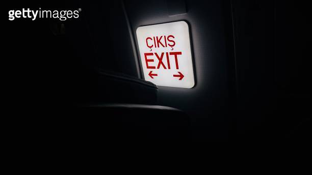 Dark Aircraft Interior with Illuminated Exit Sign in English and ...