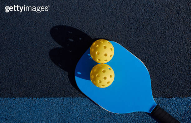 Pickleball paddle and balls on court, shot directly from above in flat ...
