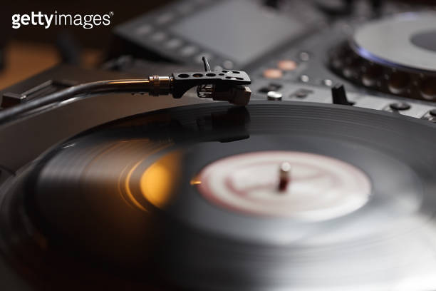 Turntables needle playing music from analog vinyl disc in close up ...