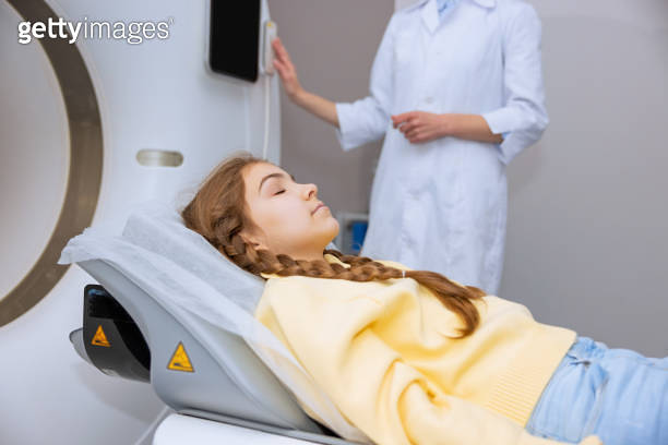 Little girl lying in mri scan machine unrecognizable radiographer ...