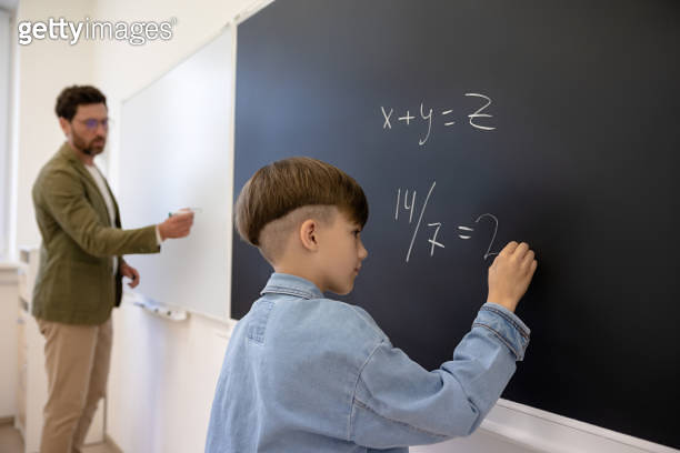 The boy answering at the maths lesson and writing on the board 이미지 ...