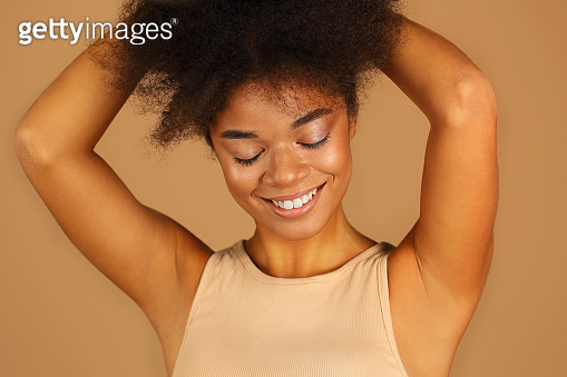 Young lovely african american woman with arms raised demonstrating ...