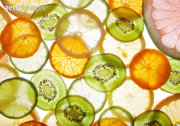 Sliced citrus fruit cross sections on white background. Food background ...