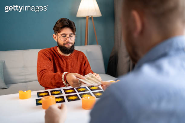fortune teller demonstrating card to customer during fortune telling ...