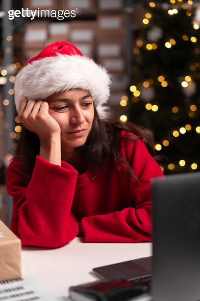Portrait of tired retail warehouse manager woman wearing santa claus ...