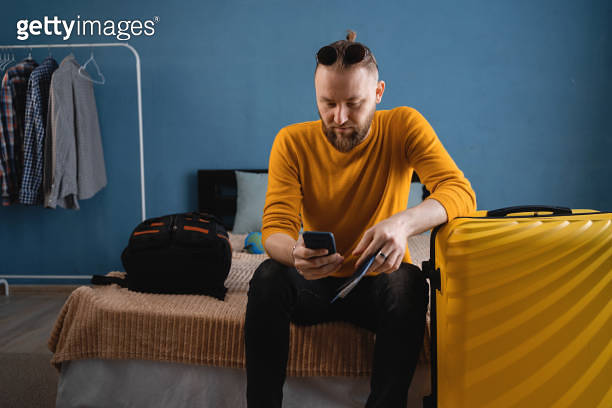 Traveler man in casual clothes with suitcase using mobile cell phone ...
