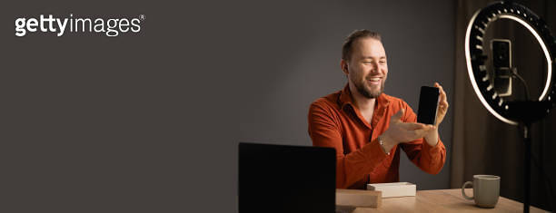 Tech male vlogger doing unpacking review video of mobile phone while ...