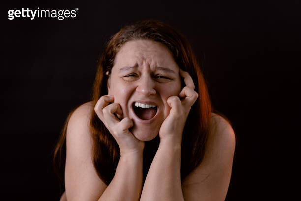 Young crying woman scratching face. Shout and scream loud with open ...