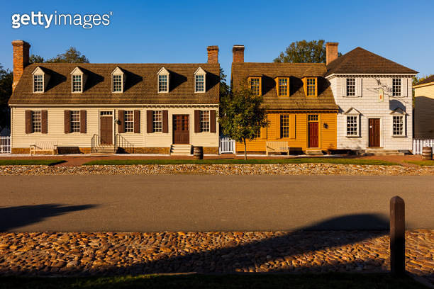 Sunny paving stone street with colonial row houses in Colonial ...