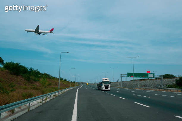 Plane flying over the city highway and truck 이미지 (1491754916) - 게티이미지뱅크