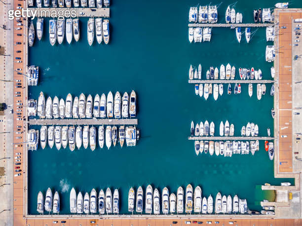 Aerial view of a square shaped marina with moored sailboats and super ...