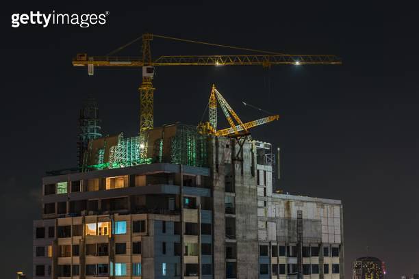Crane in high building construction site with lighting at night. 이미지 ...